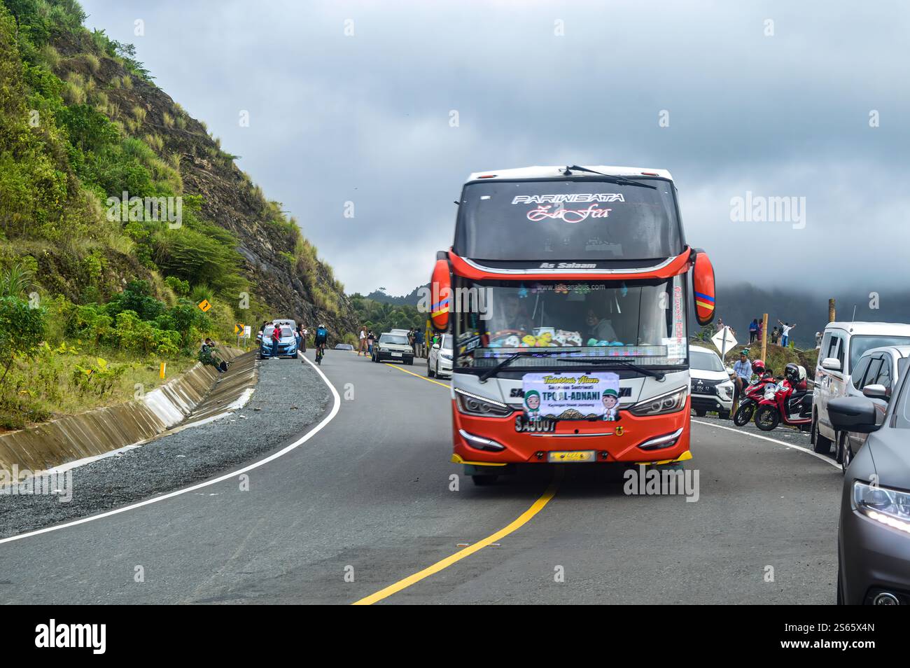 an Indonesian tourist bus is speeding through a sharp turn in a ...