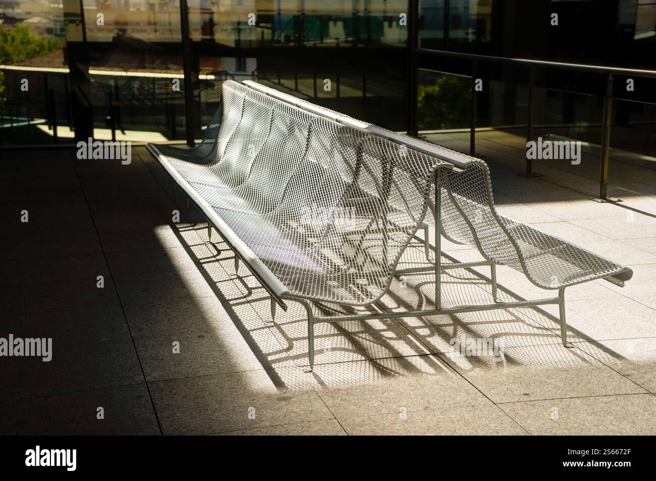 A metal mesh benches on the floor of building Stock Photo - Alamy
