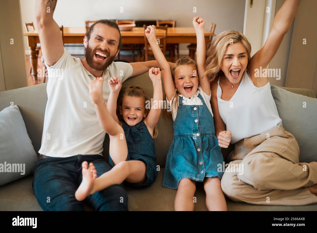 Parents, children and watching tv with cheering on sofa for football ...