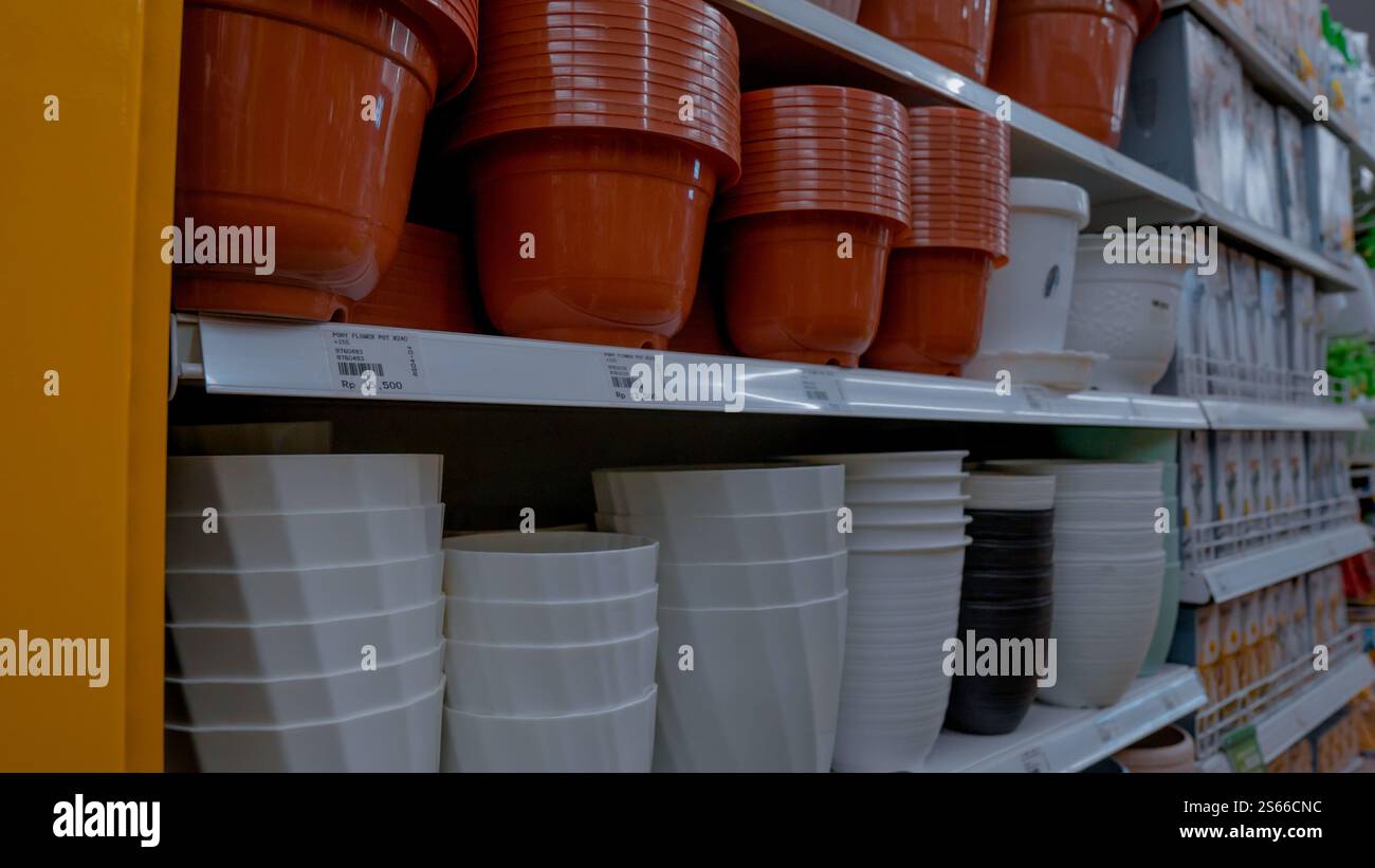 A display of various flower pots arranged on shelves in a store. The ...