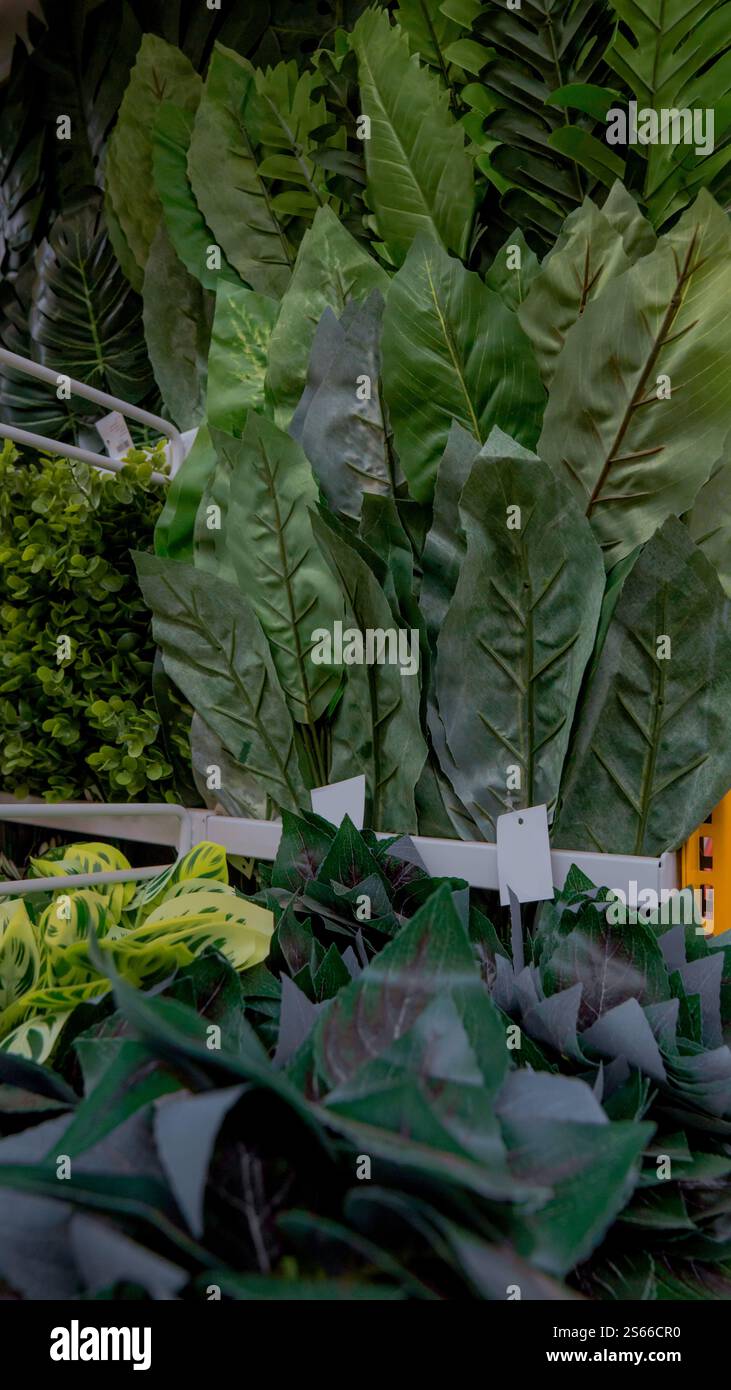 A variety of artificial green leaves displayed in a store, showcasing ...