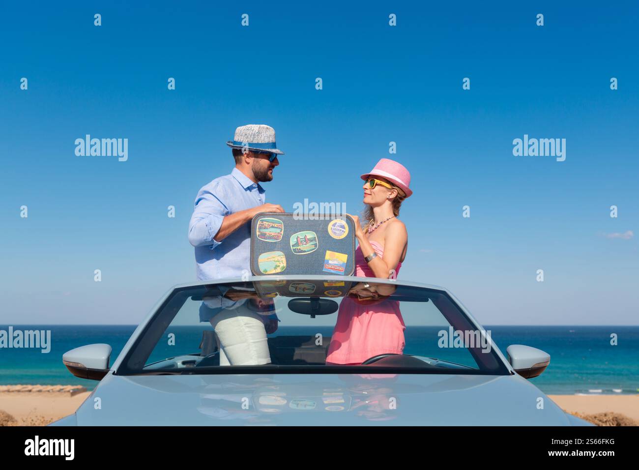 Happy couple in love travel by car by the sea. Young man and woman ...
