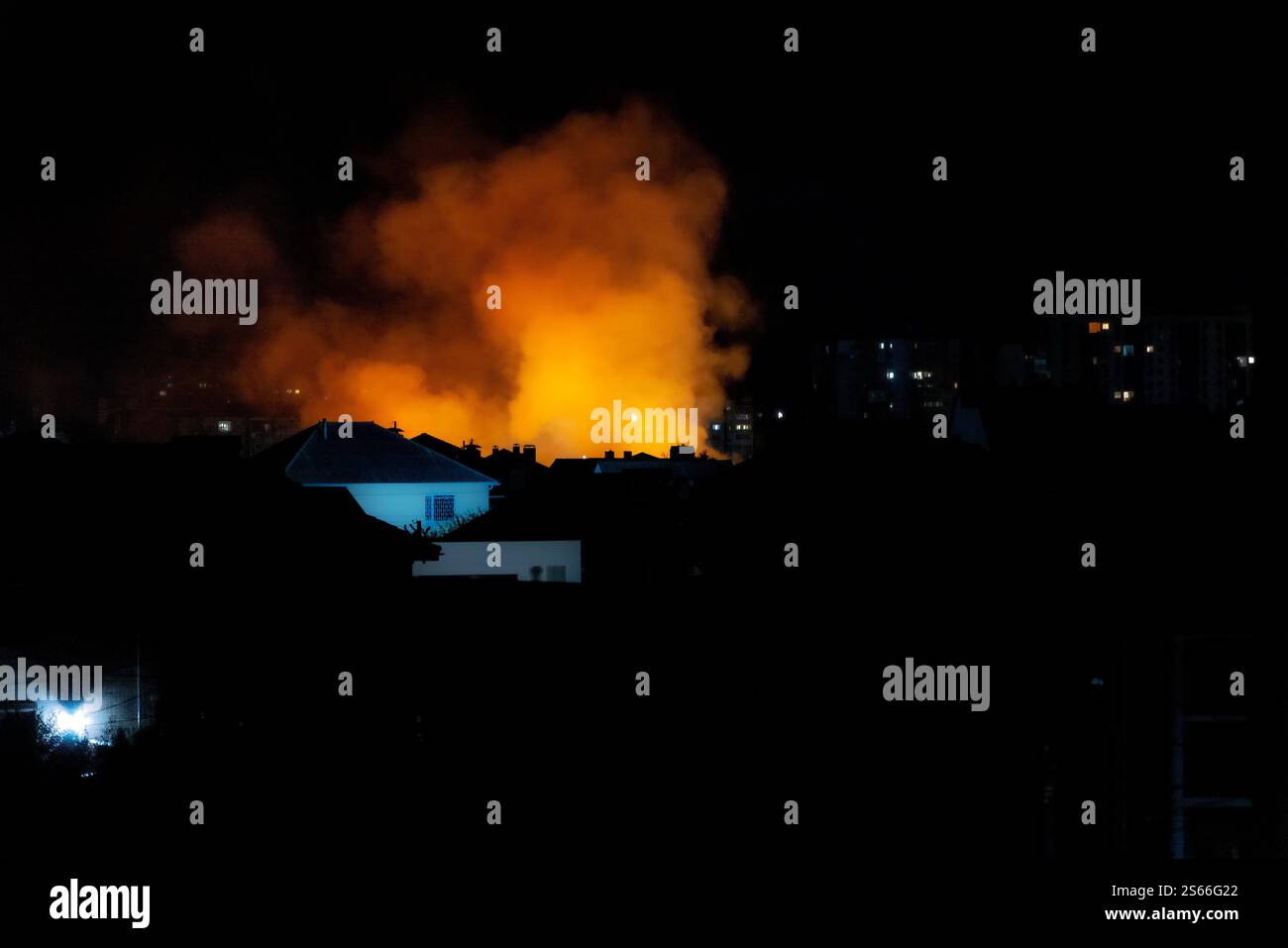Night fire in residential area with cottage and high-rise buildings in ...