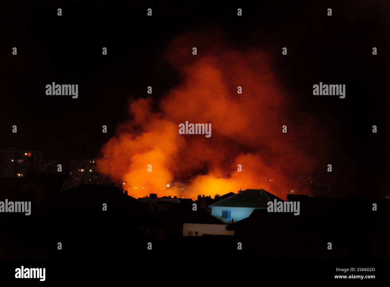 Night fire in residential area with cottage and high-rise buildings in ...