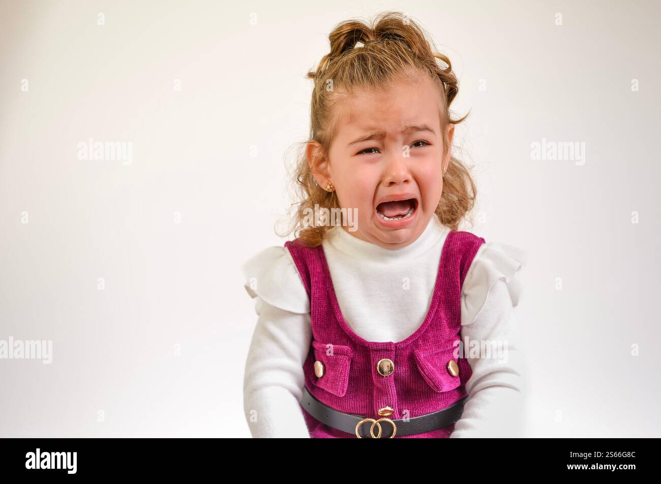Portrait of a preschool girl crying desperately with tears rolling down her cheeks, expressing ...