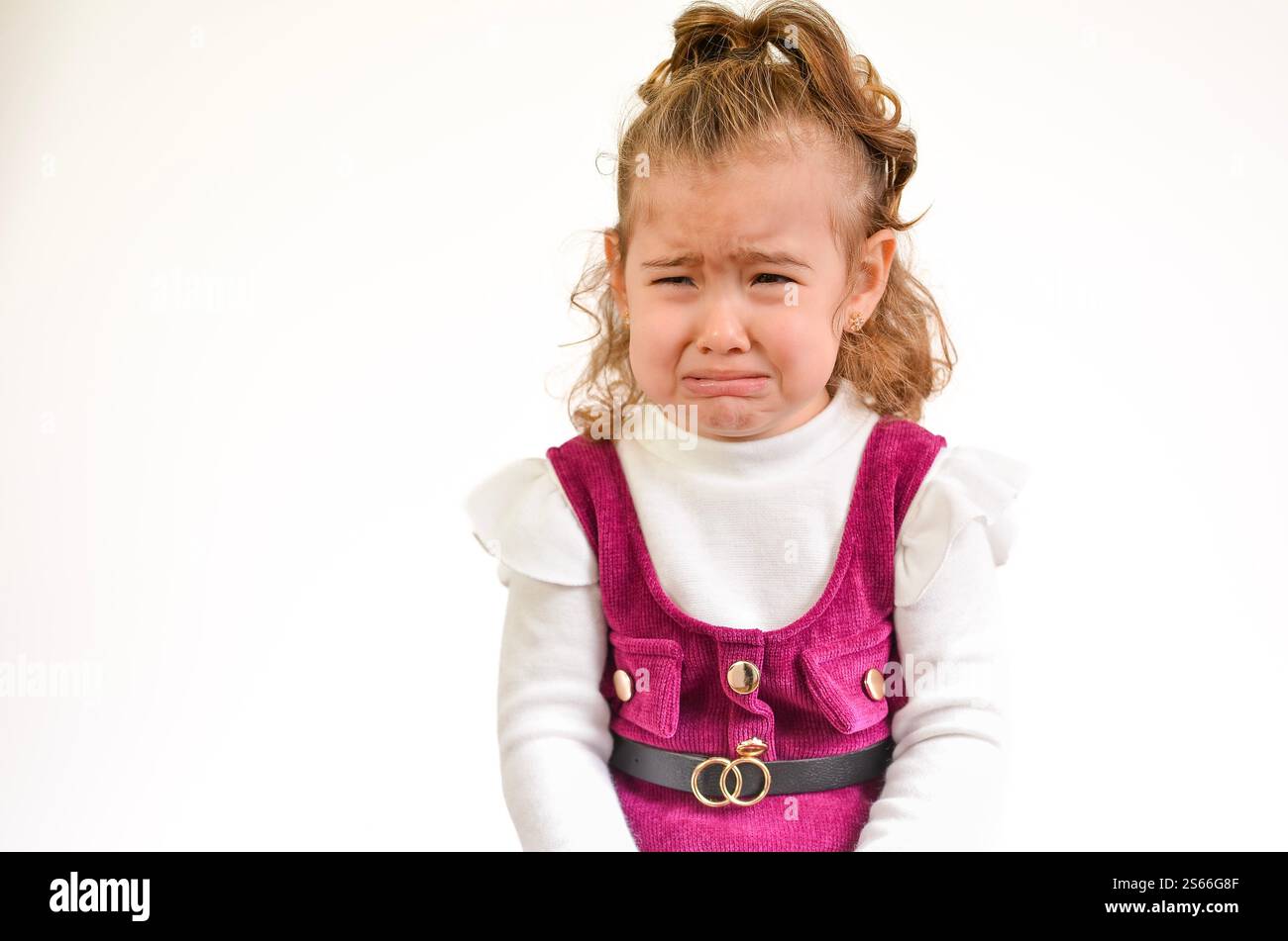 Portrait of a sad little girl crying desperately on white background ...