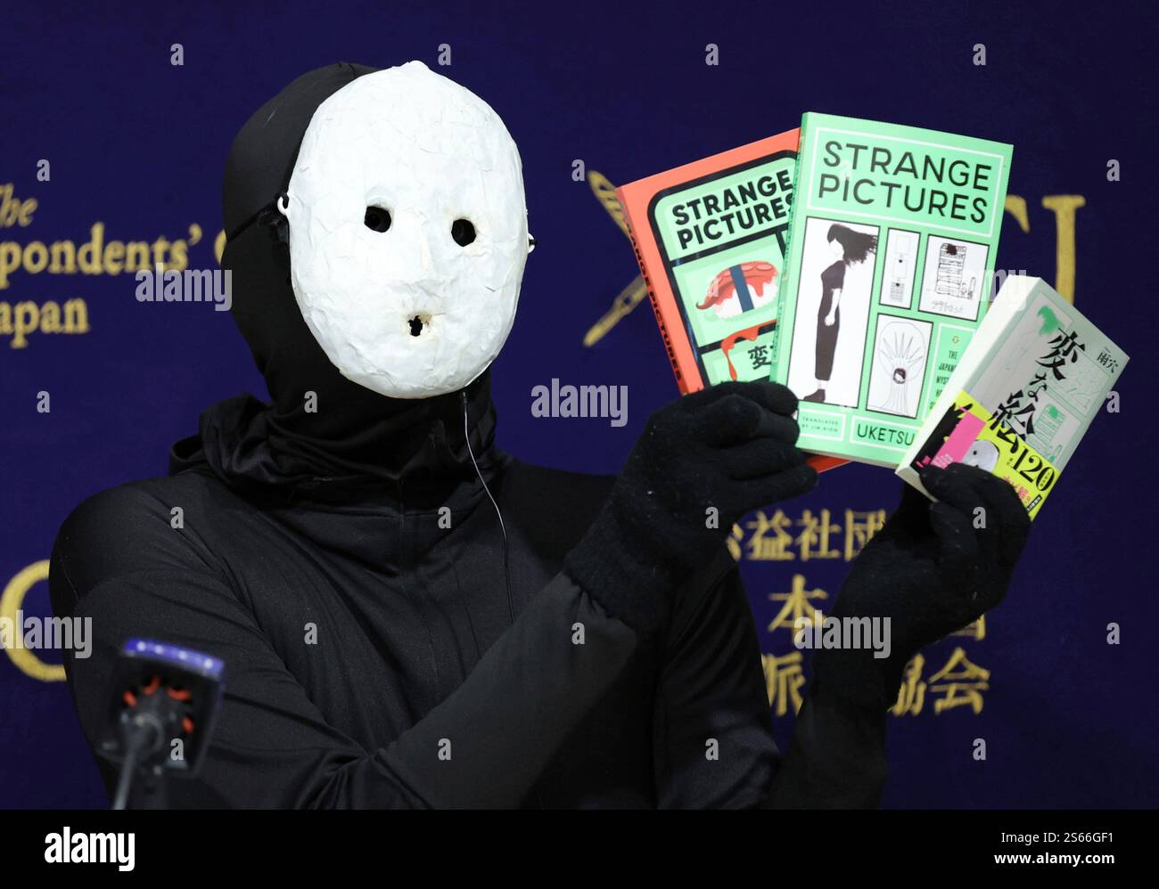 Uketsu, a Japanese horror author, and YouTuber, holds his books at ...