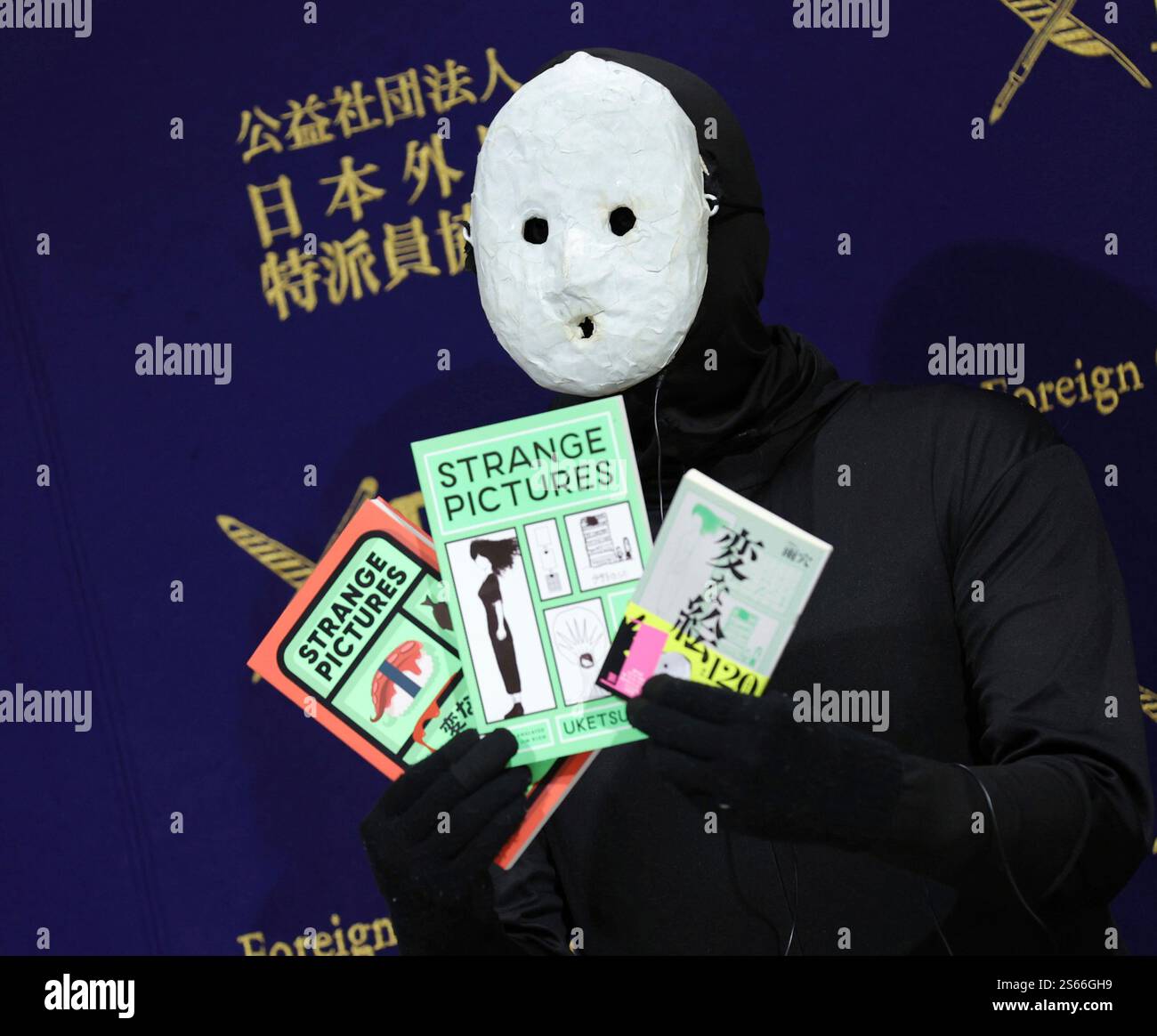 Uketsu, a Japanese horror author, and YouTuber, holds his books at ...