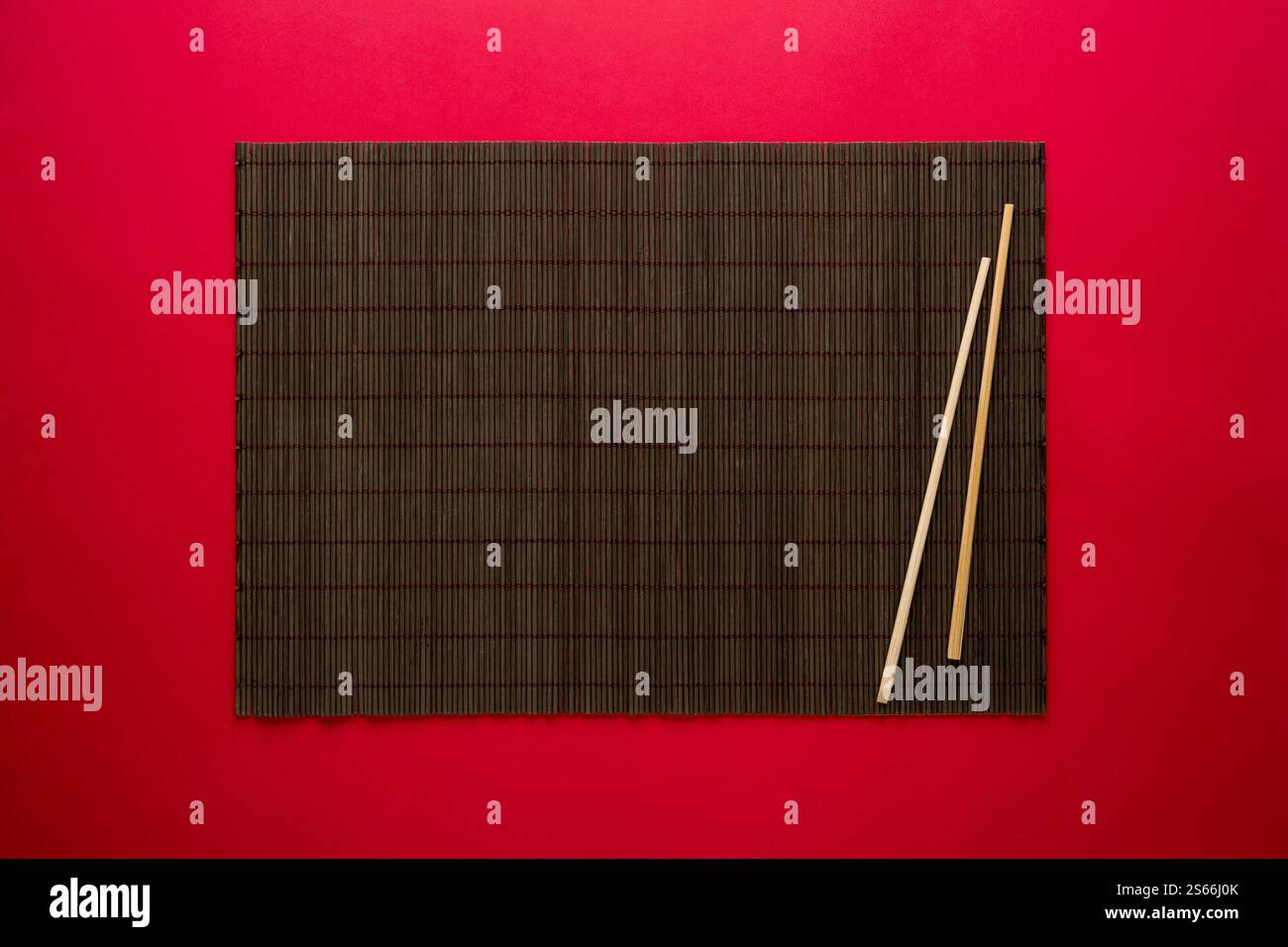 Sushi sticks and empty bamboo mat on red background Stock Photo - Alamy
