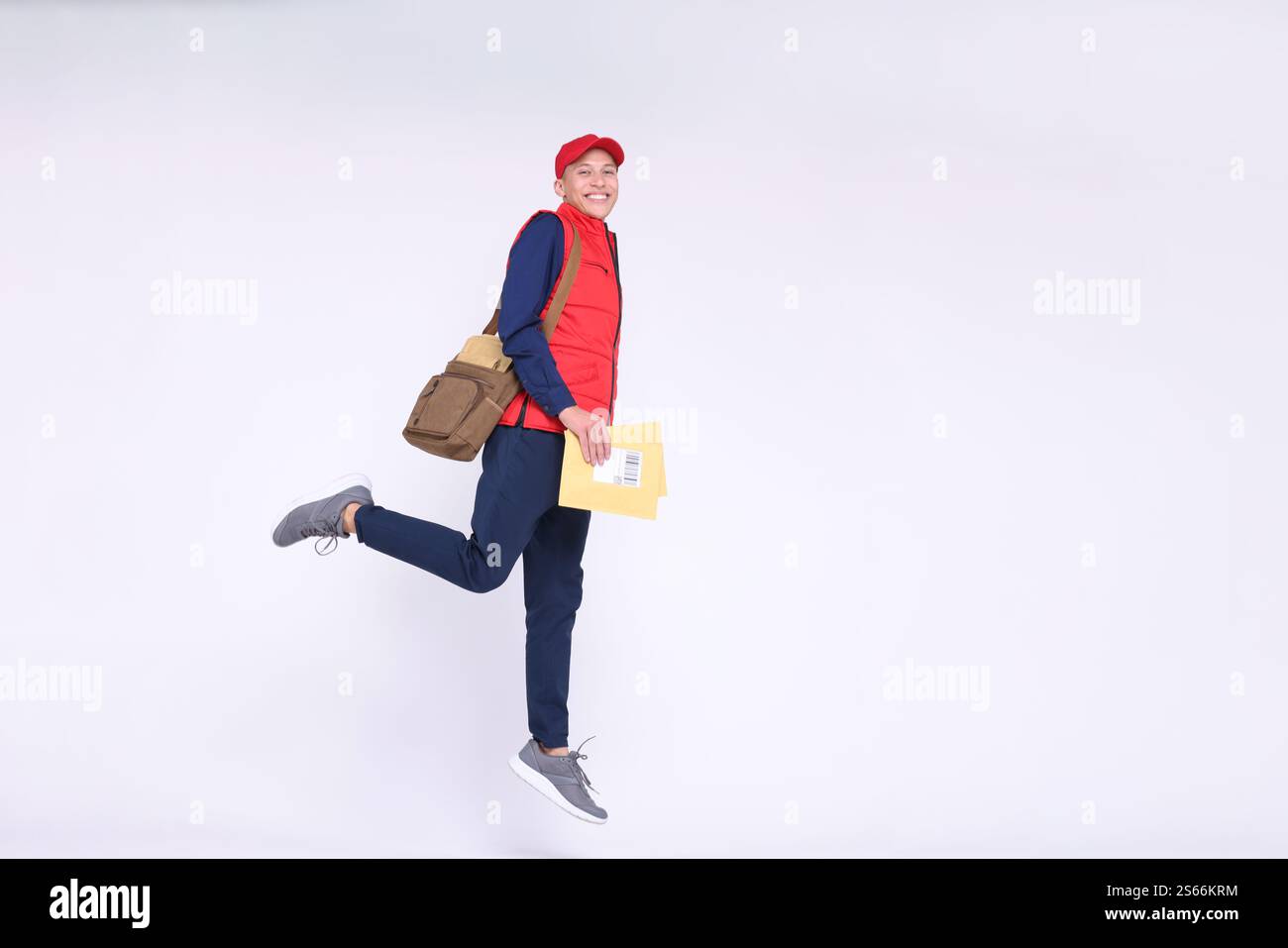 Happy postman with bag and envelopes jumping on white background Stock ...