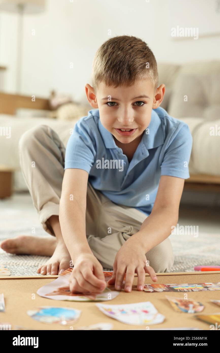Little boy creating vision board with different pictures and other ...