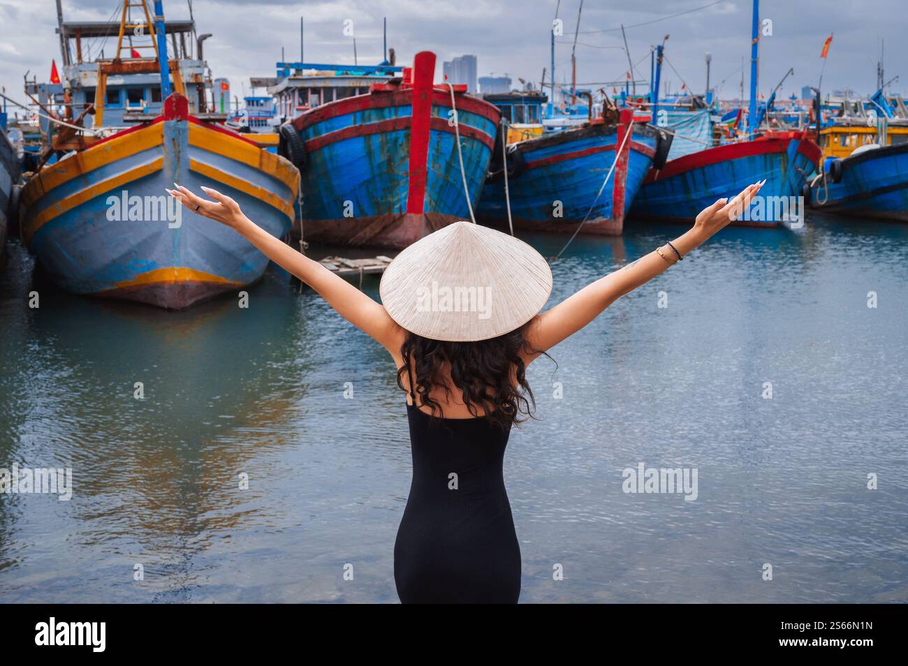 A female traveler wearing a traditional Vietnamese hat inspects ...
