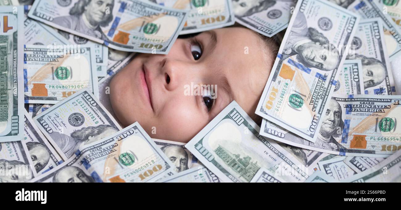 Kid with fun face in money. Kid peeking out of dollar bills with ...