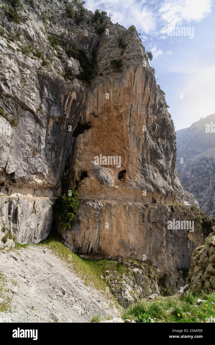 A large rock formation with a small opening in it. The rock is covered ...