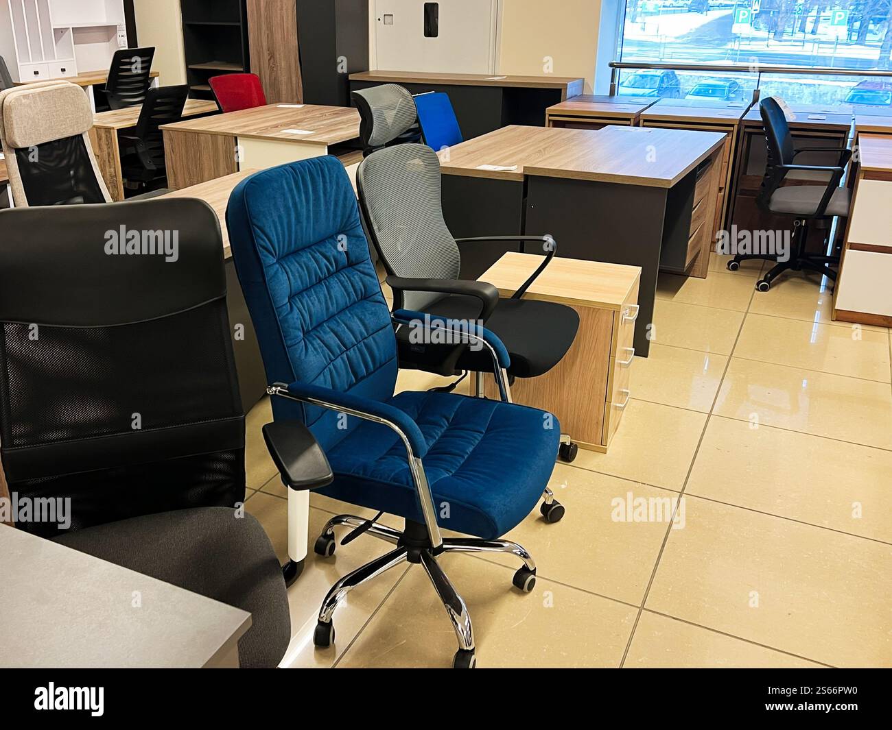 A modern office showroom exhibiting a variety of desks and chairs in ...