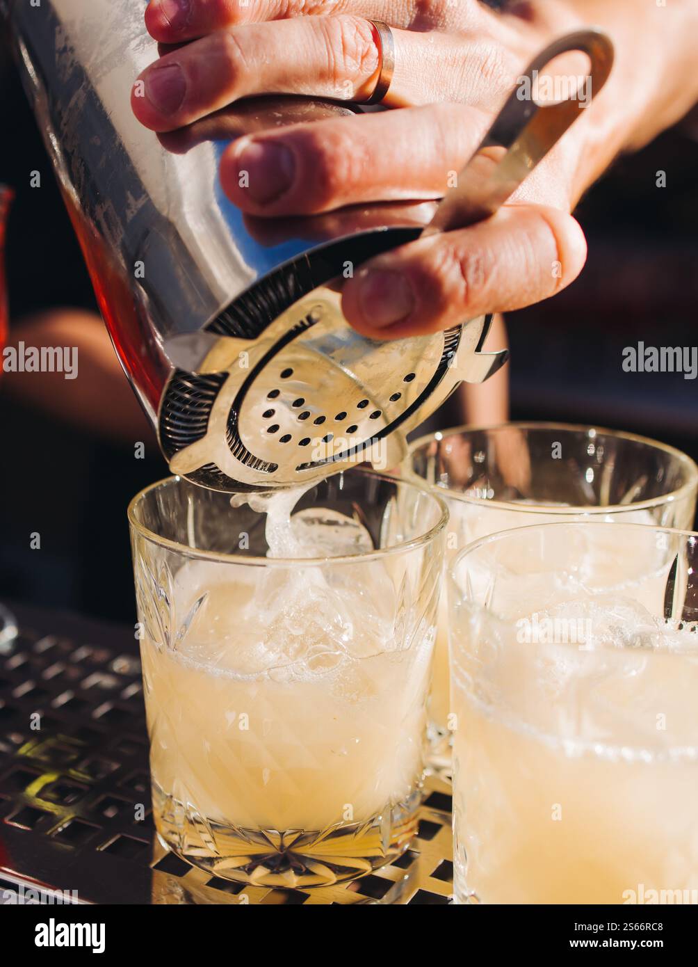 Bartender working, beautiful row line of different coloured liquor ...