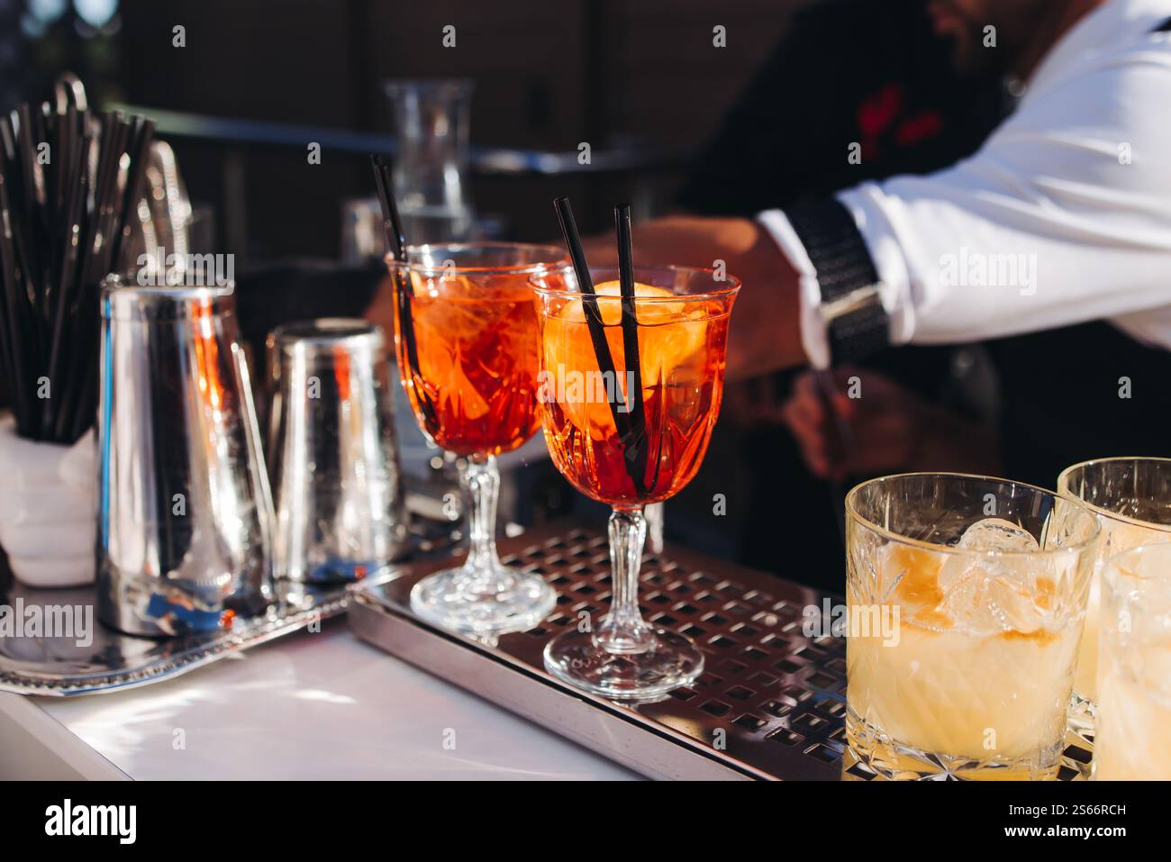 Bartender working, beautiful row line of different coloured liquor ...