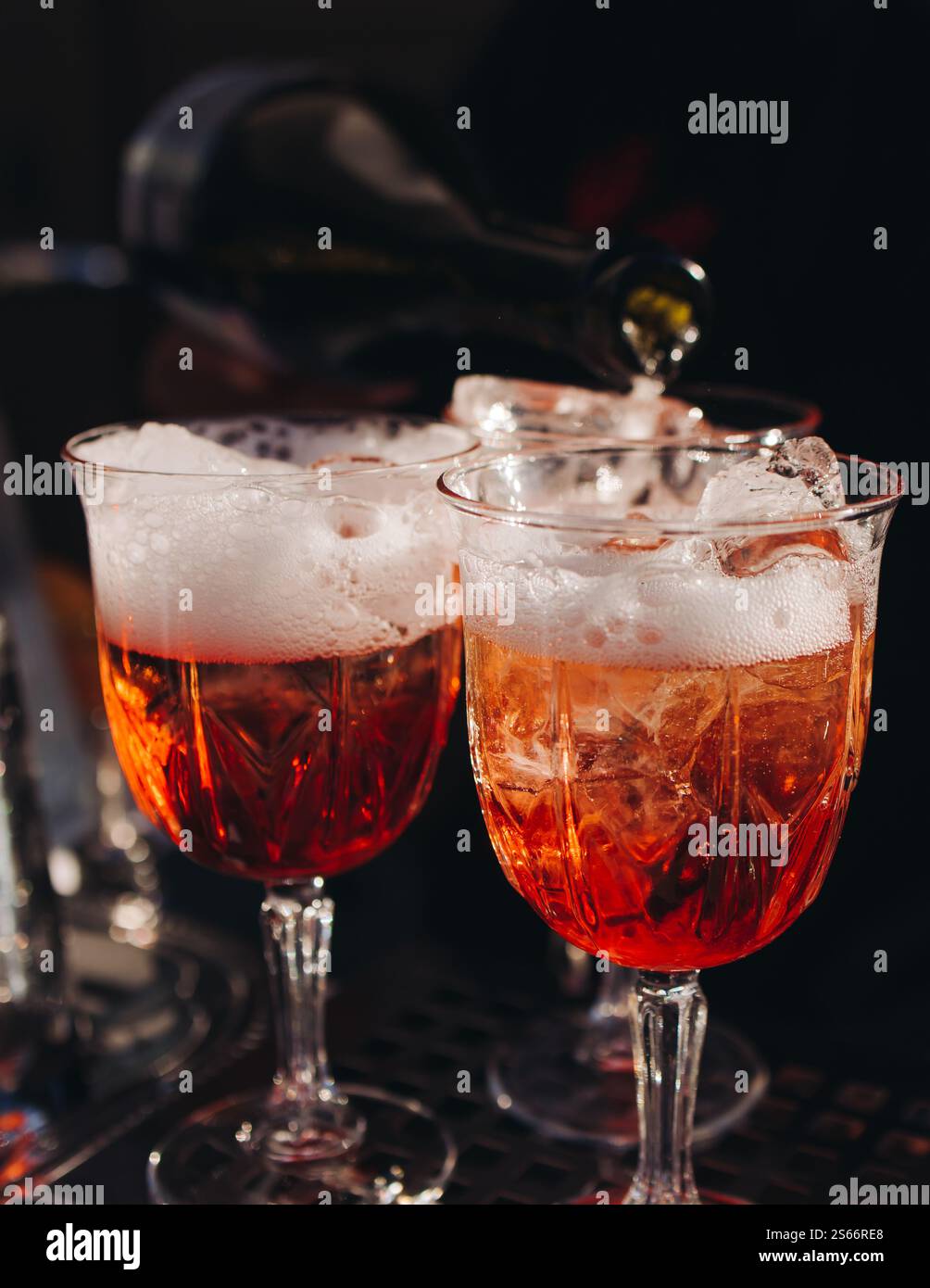 Bartender working, beautiful row line of different coloured liquor ...