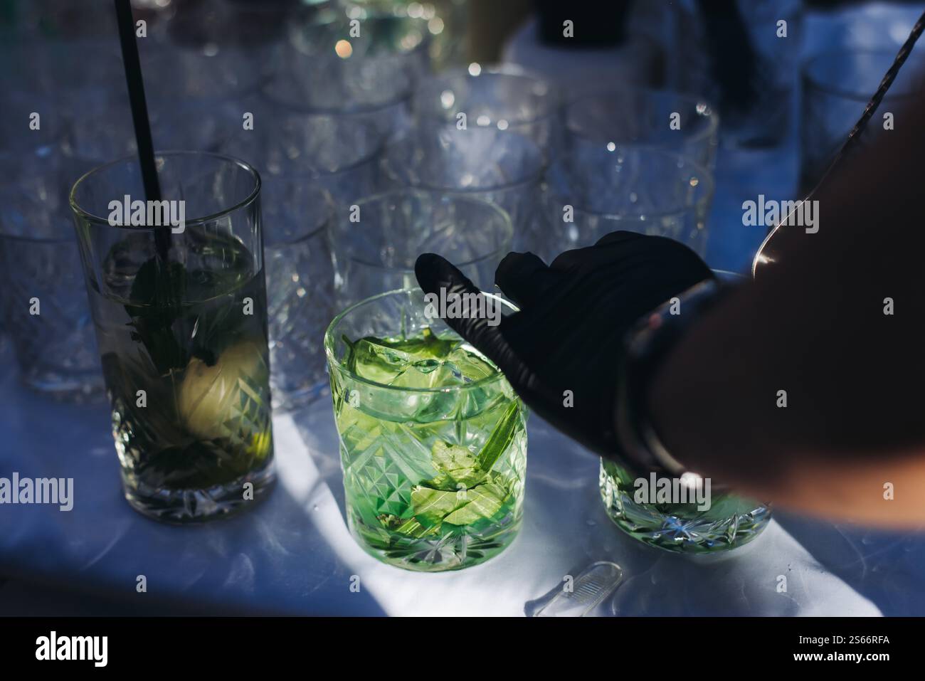 Bartender working, beautiful row line of different coloured liquor ...