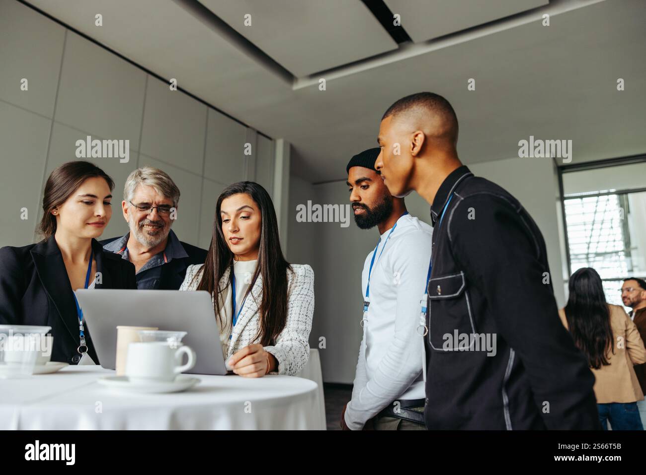 Corporate team at a business event collaboratively working around a ...