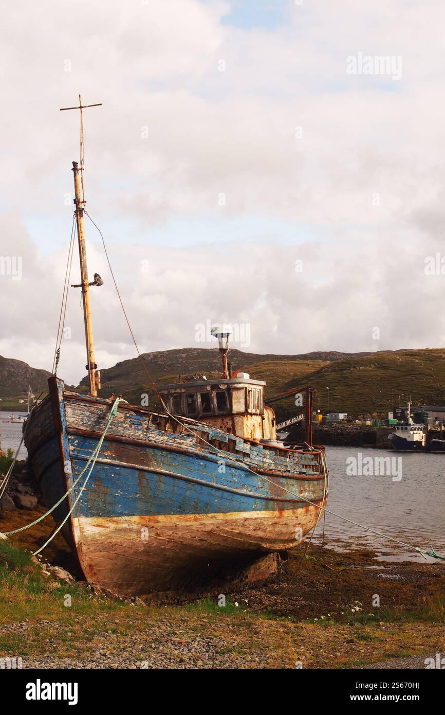 An abandoned, decaying, fishing vessel, out of the water, on the ...