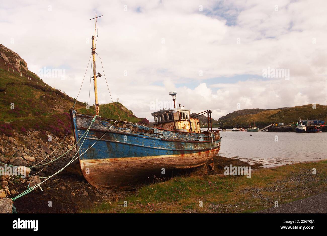 An abandoned, decaying, fishing vessel, out of the water, on the ...