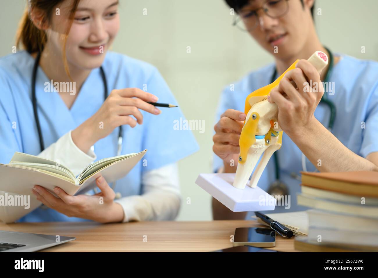 Medical students in scrubs studying anatomy with joint model on the ...