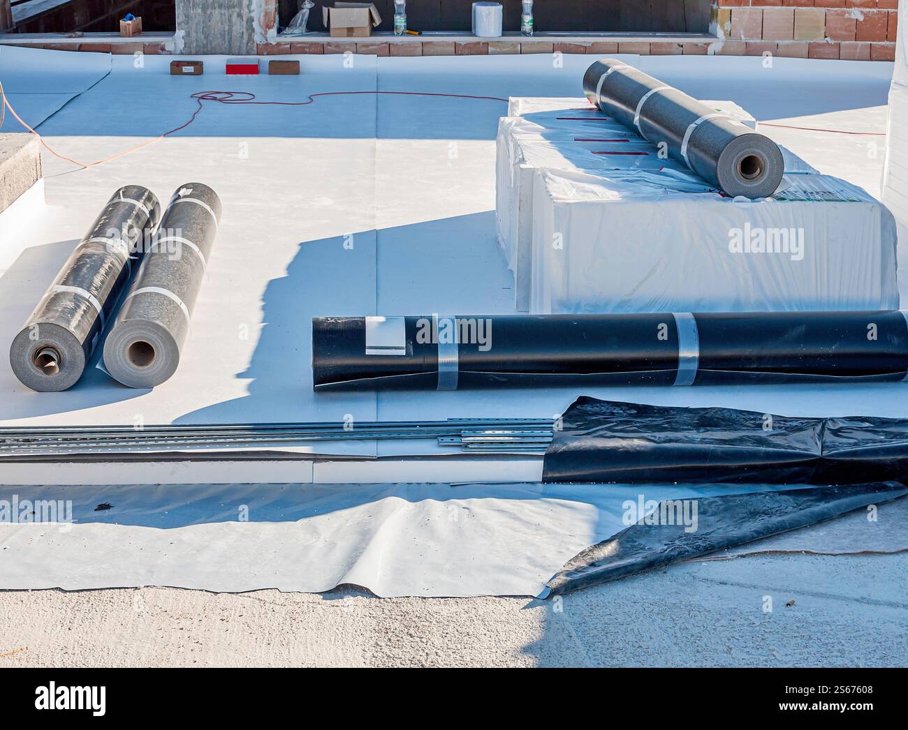 Construction site with a flat roof being waterproofed. The image shows ...