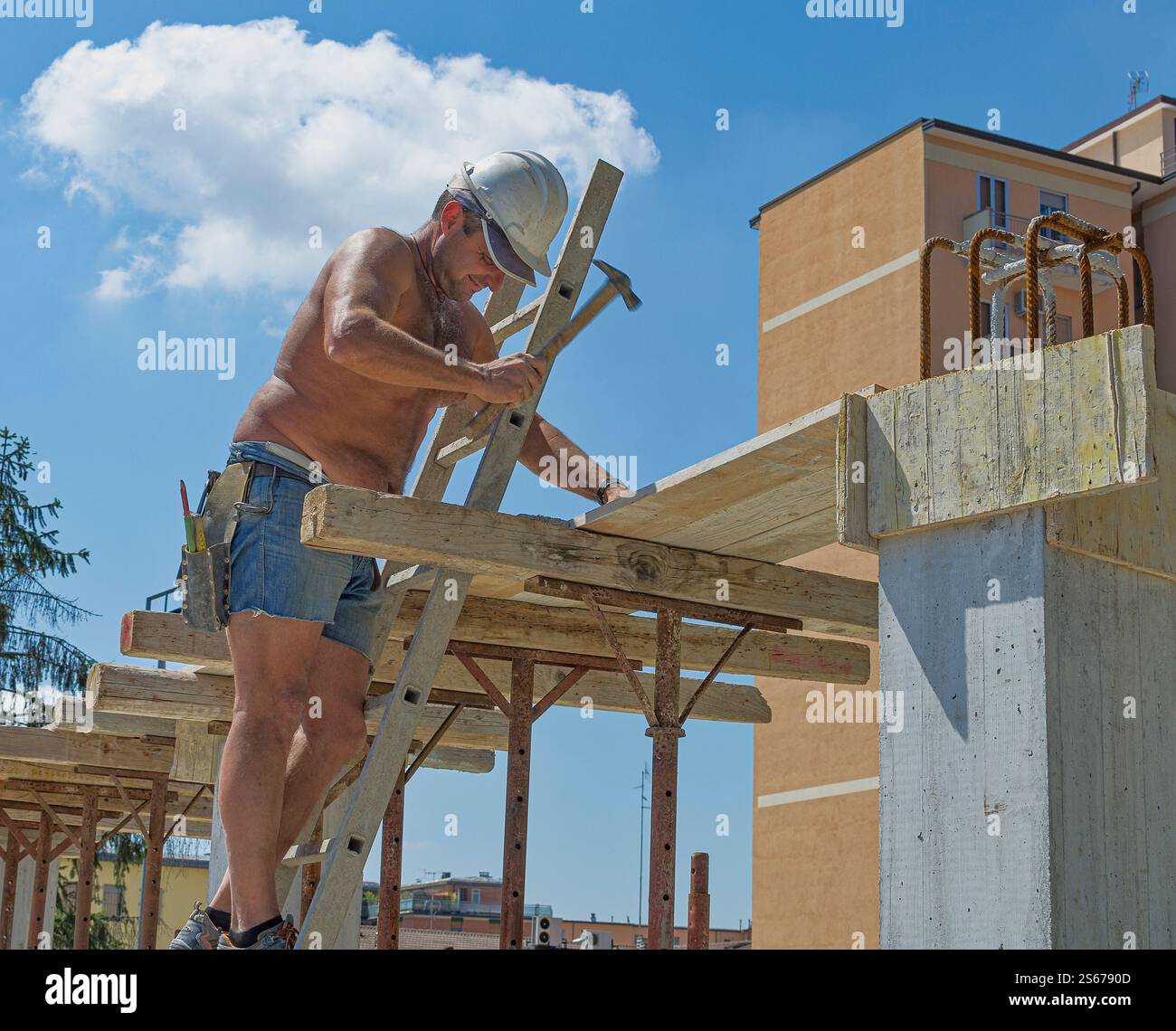 construction worker carpenter on a construction site makes a wooden ...