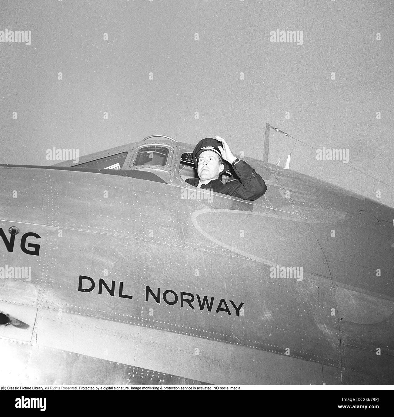 A pilot has opened the window of the cockpit of a DC3 passenger plane ...