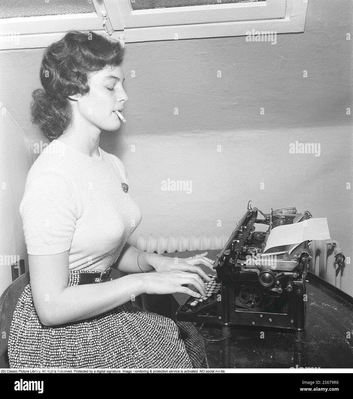 A woman in the 1950s. A young woman at a typewriter, dressed in a ...
