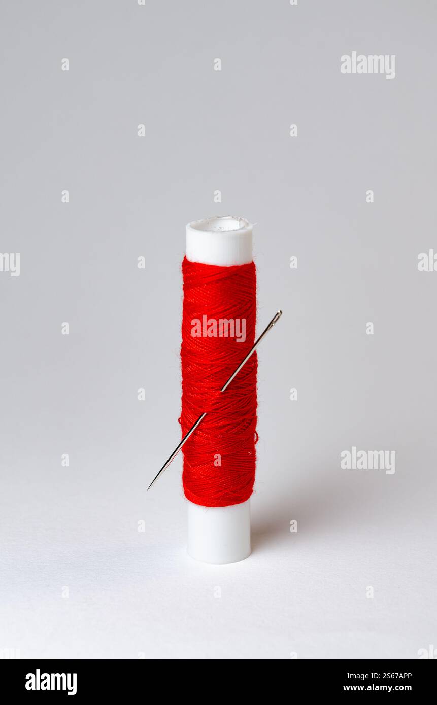 One single red thread spool with needle on white background Stock Photo ...