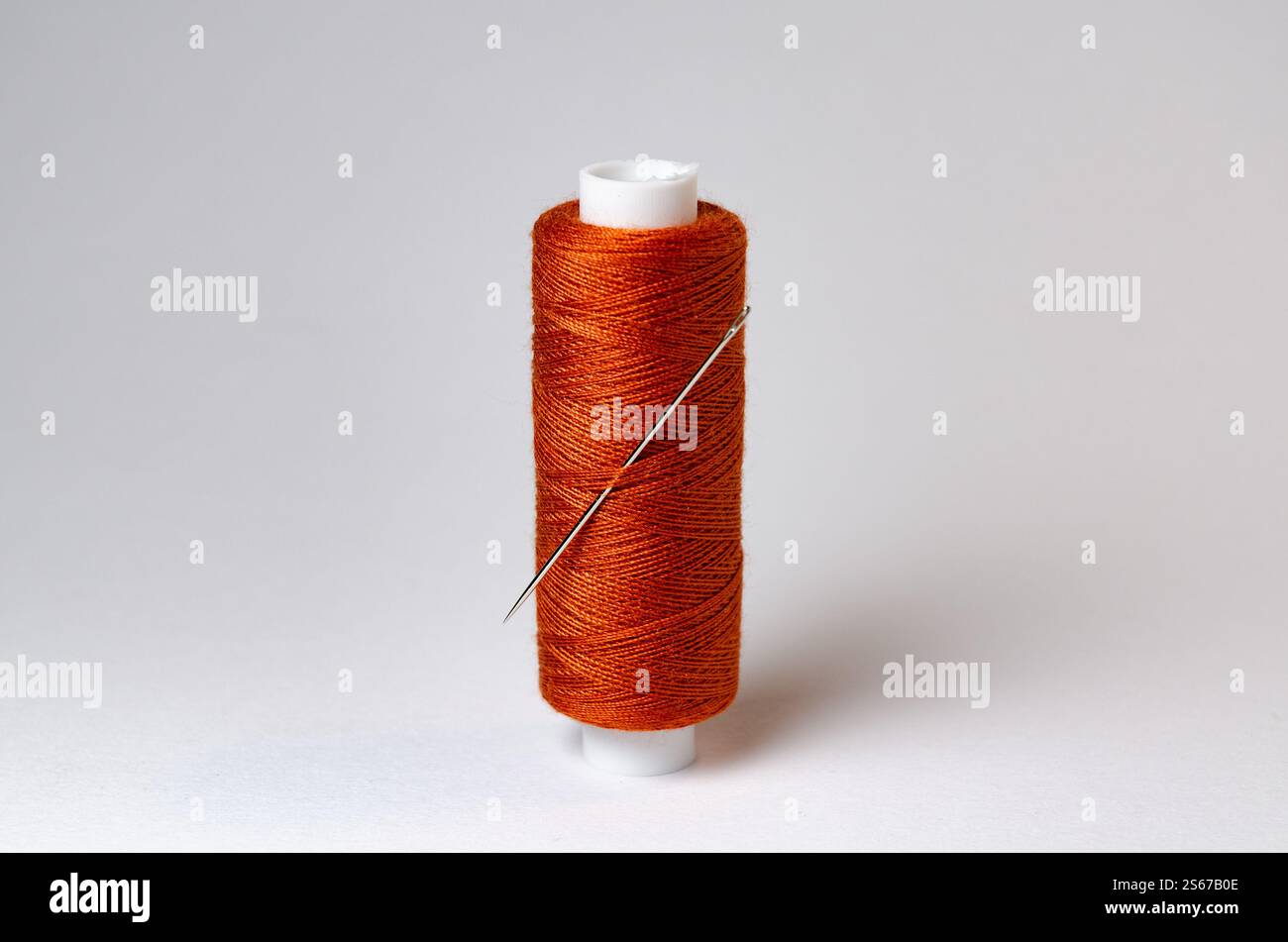 One single red thread spool with needle on white background Stock Photo ...