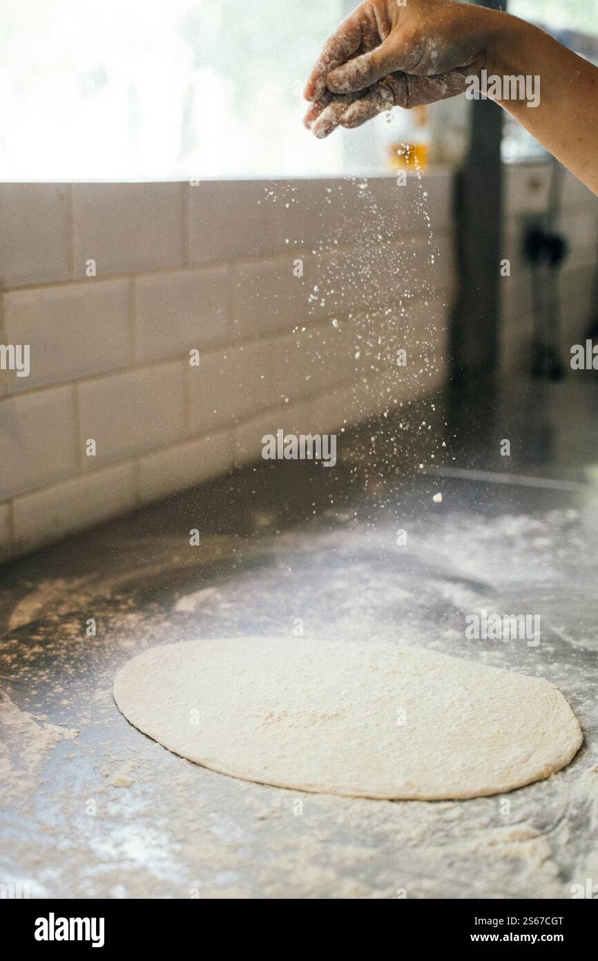 A Person Sprinkling Flour on the Pizza Dough Stock Photo - Alamy