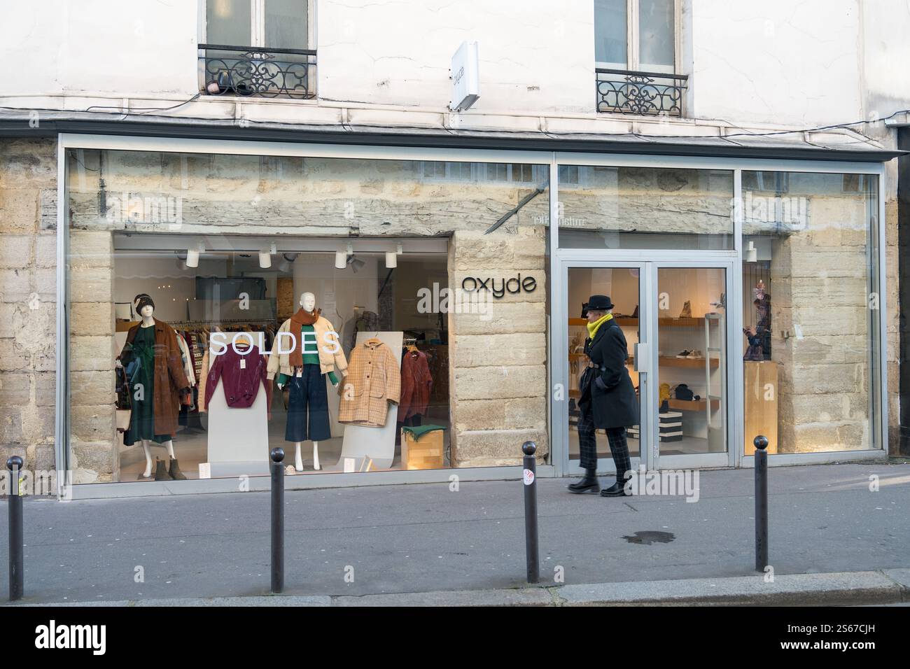 Storefront display with sale signs and a customer in Paris Stock Photo ...