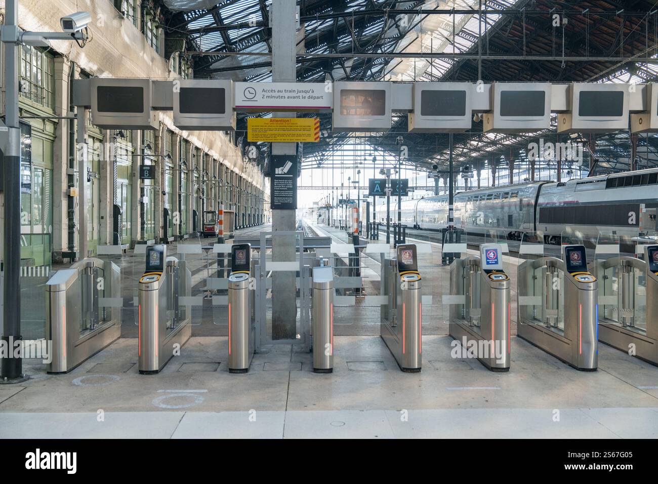 Modern train station entrance with ticket barriers and empty platform ...
