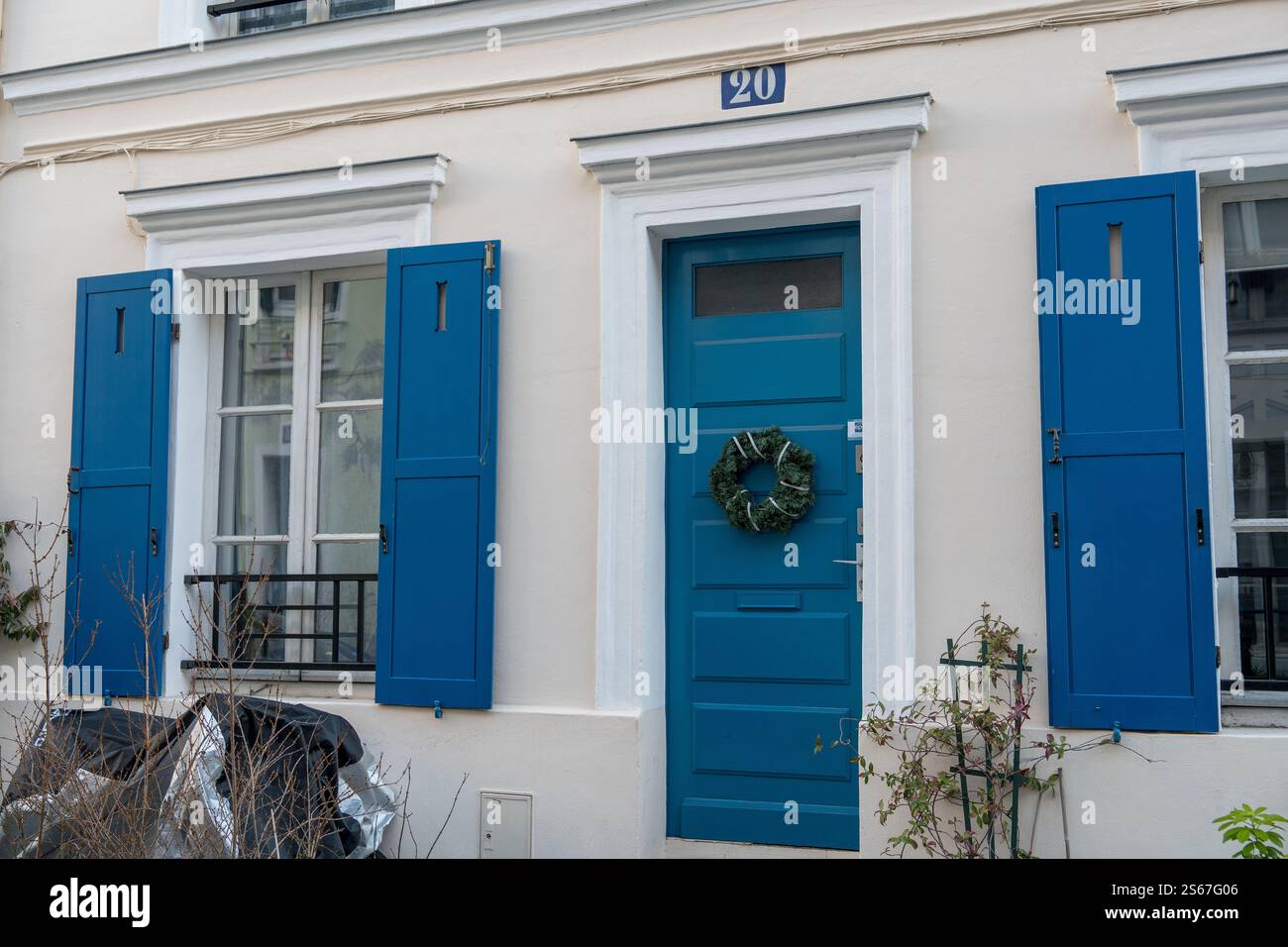 Blue door with shutters and wreath at building number 20 in a city ...
