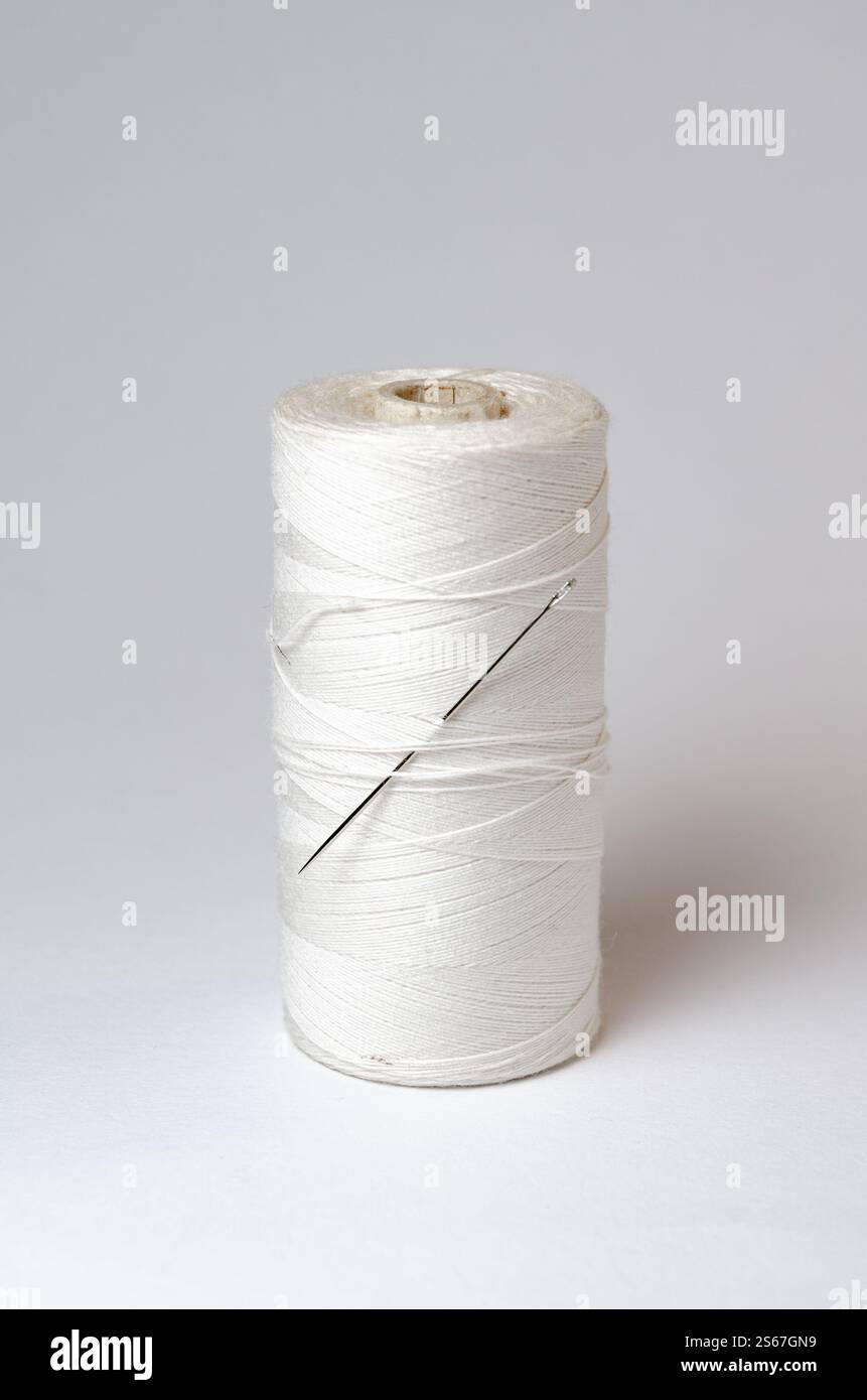 One single thread spool with needle on white background Stock Photo - Alamy