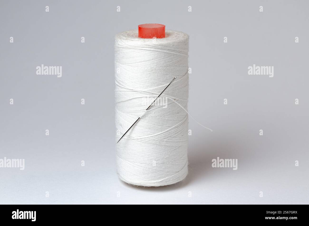 One single thread spool with needle on white background Stock Photo - Alamy