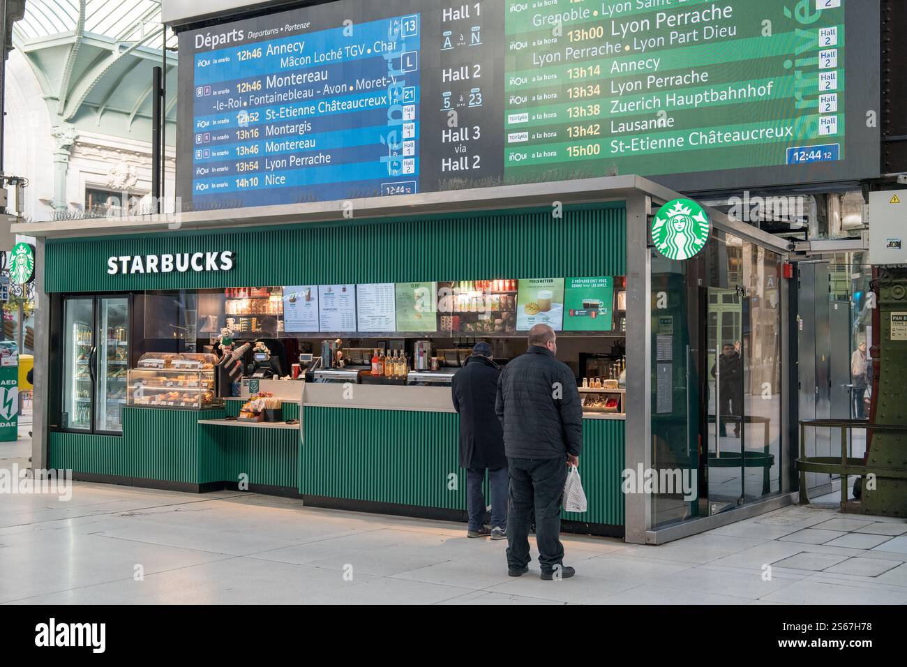 Coffee shop in a busy train station with travelers enjoying beverages ...