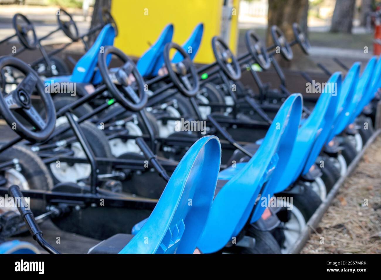 a row of row-a-row go-kart seats with bright blue seats Stock Photo - Alamy
