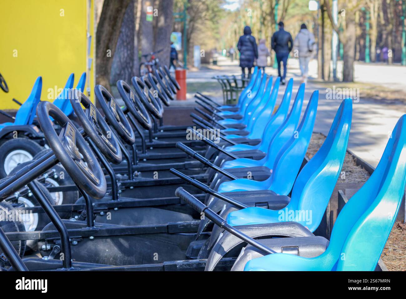 a row of row-a-row go-kart seats with bright blue seats Stock Photo - Alamy