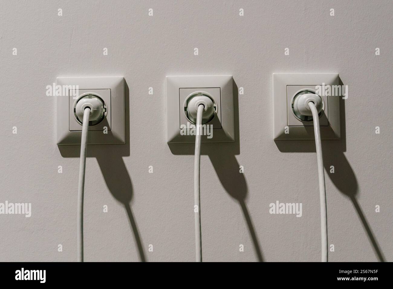 white electrical sockets with plugs in them. connecting high-voltage ...