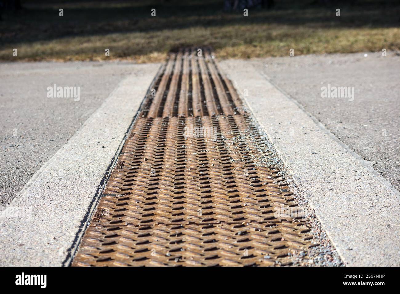 A rust-covered restored sewage channel between two concrete areas in a ...