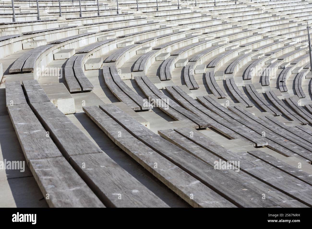 An empty, wooden-seated amphitheater with concrete structures Stock ...