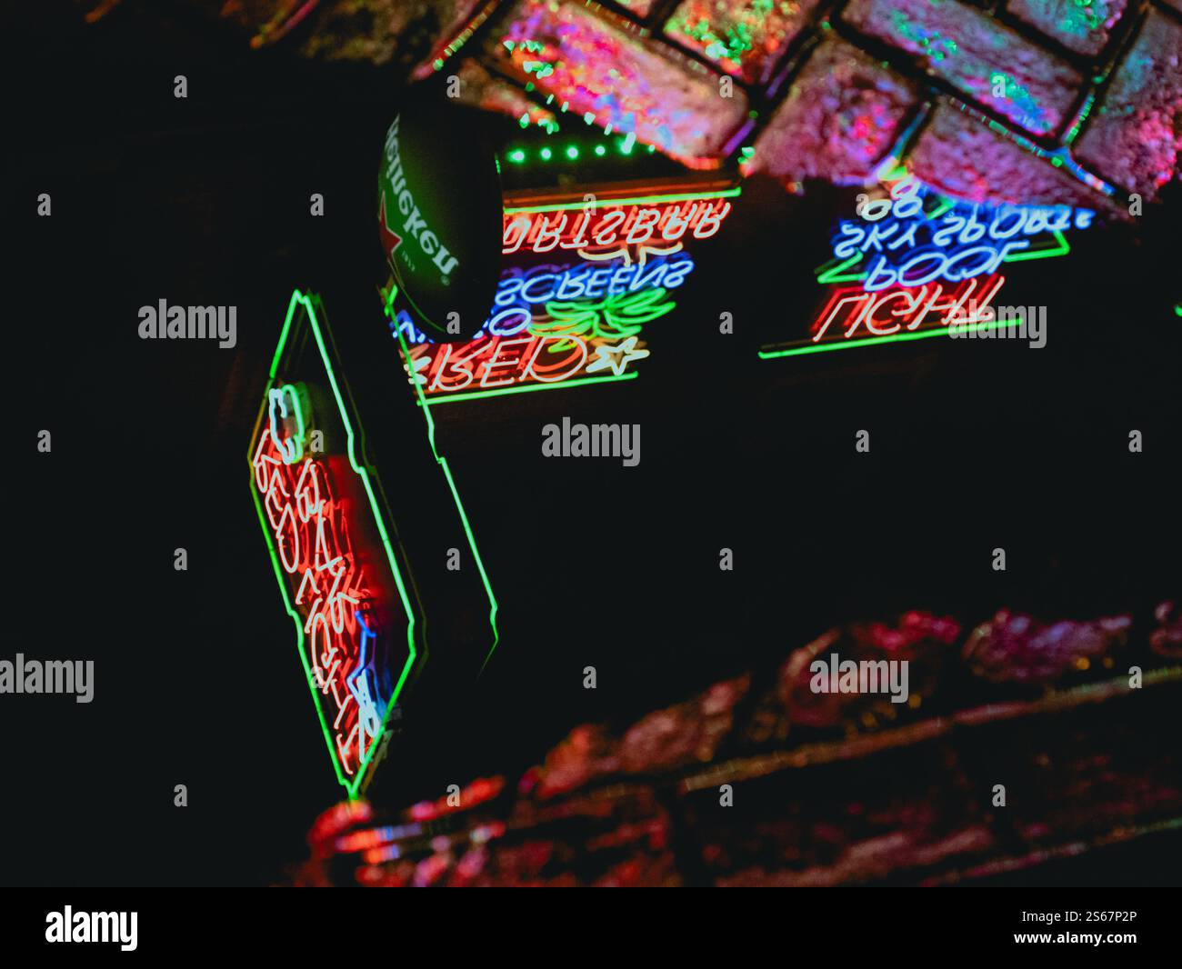 Neon sign reflected in a puddle Stock Photo - Alamy