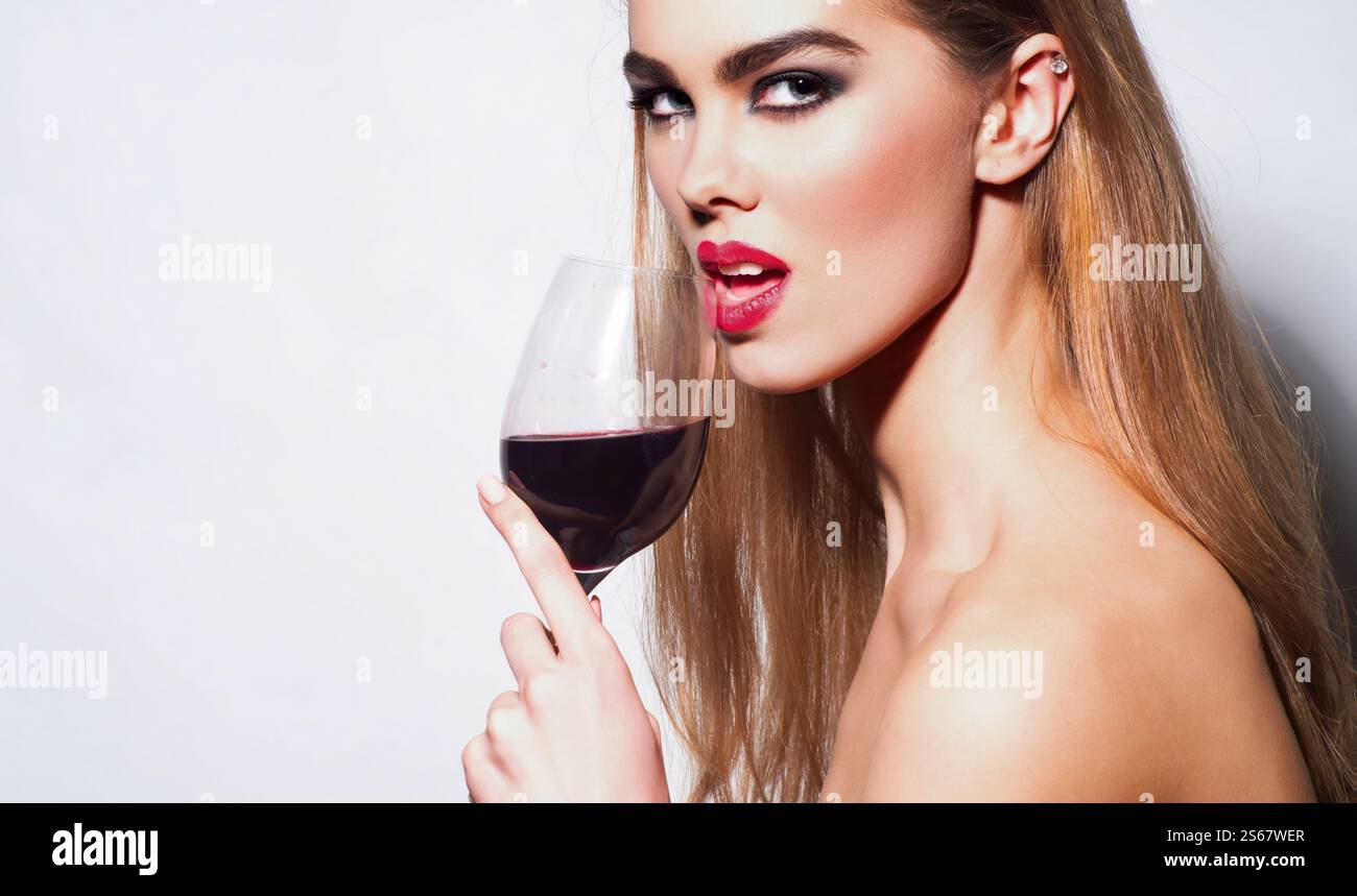 Woman hold glass with red wine. Close up portrait of female model with ...