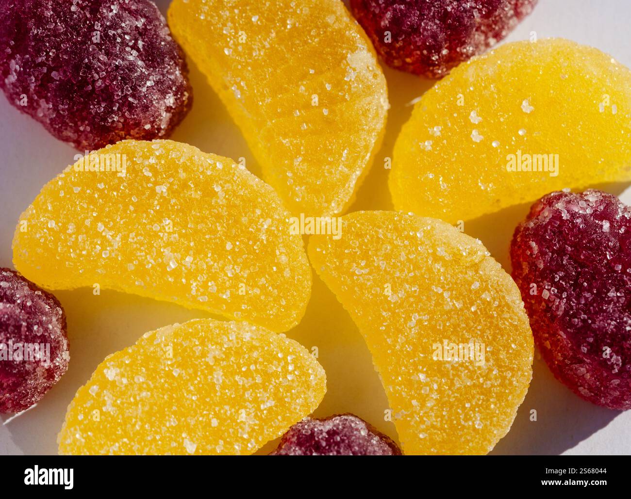 Detailed view of yellow and purple gummy candies with sugar texture on ...