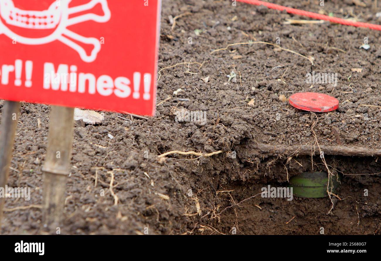 FILE -An unexploded land mine, right, lies in the field at a clearance ...