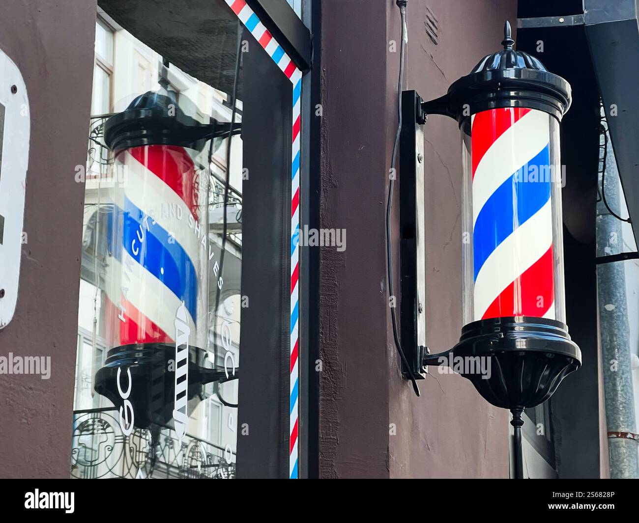A vintage barber pole displaying red, white, and blue spirals mounted ...